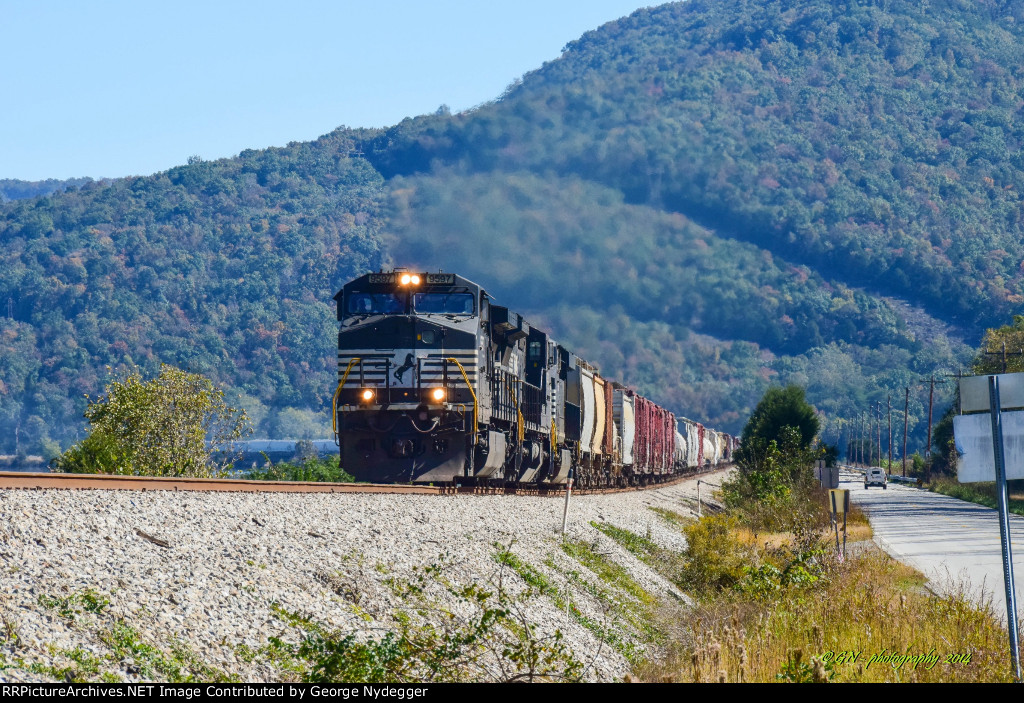 NS 9597 C40-9W is leading a mixed freight train